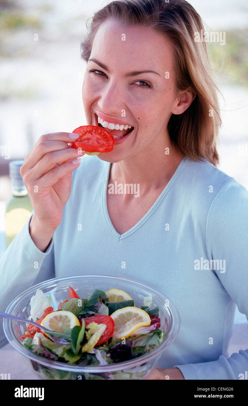 Female Shoulder Length Blonde Hair Wearing Blue Top Sitting Holding