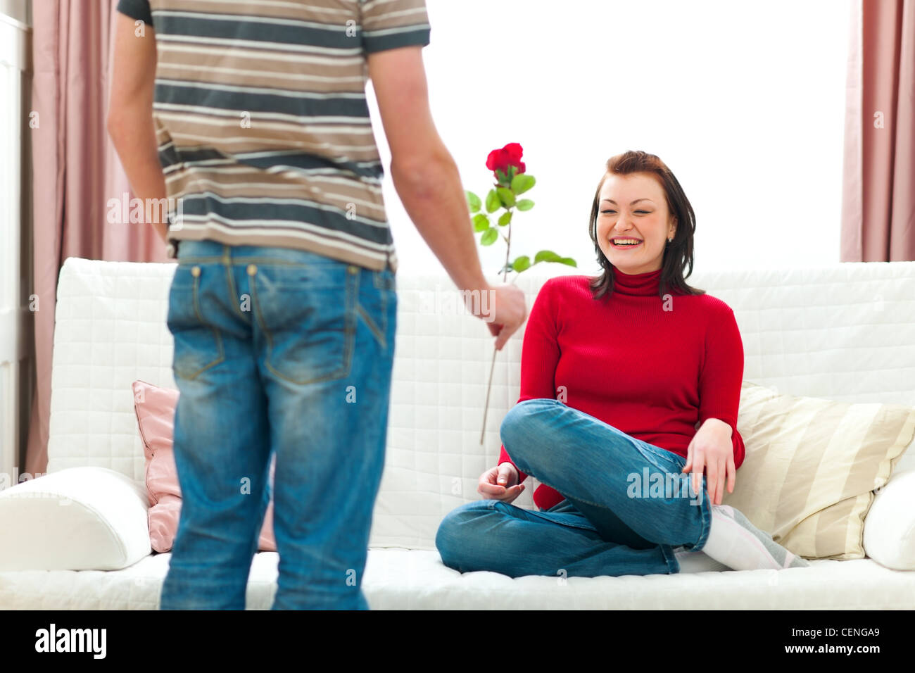 Young man presenting red rose to her girlfriend Stock Photo - Alamy