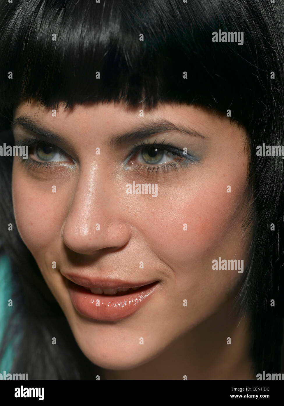 Female with dark brunette hair and fringe with blue eyeshadow, looking ...