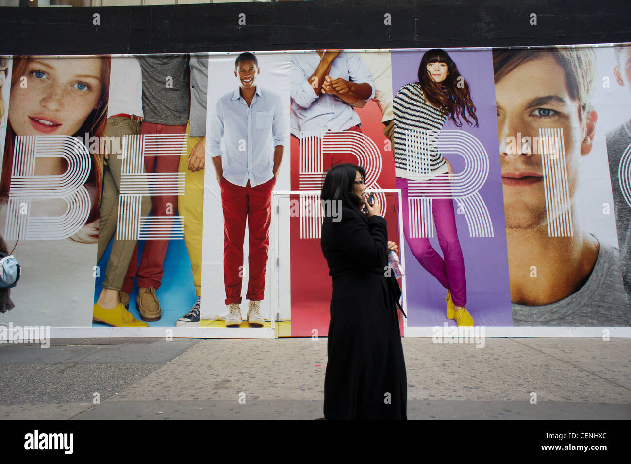Shoppers pass a promotion for a Gap clothing store, covering its ...