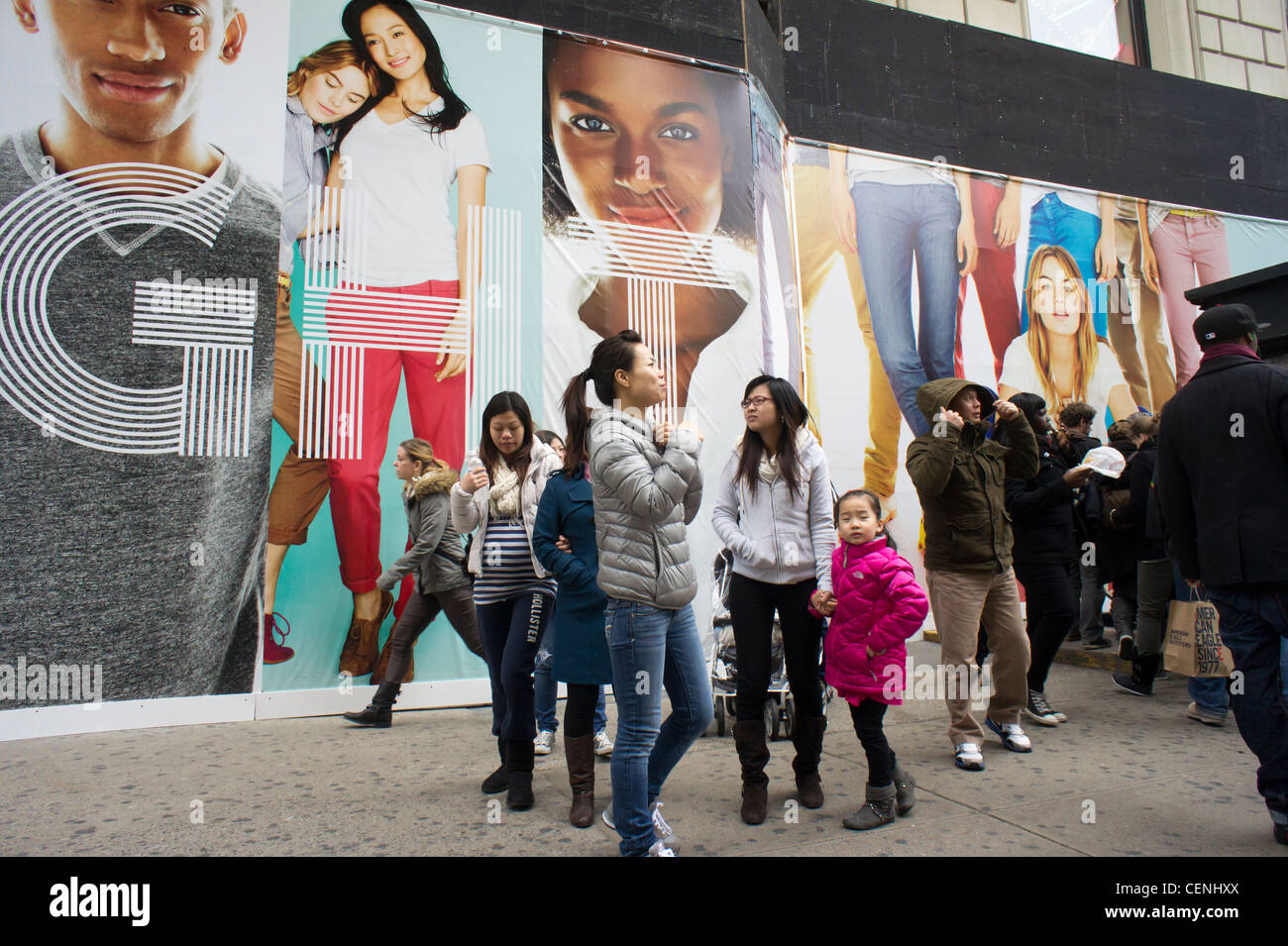 Shoppers pass a promotion for a Gap clothing store, covering its ...