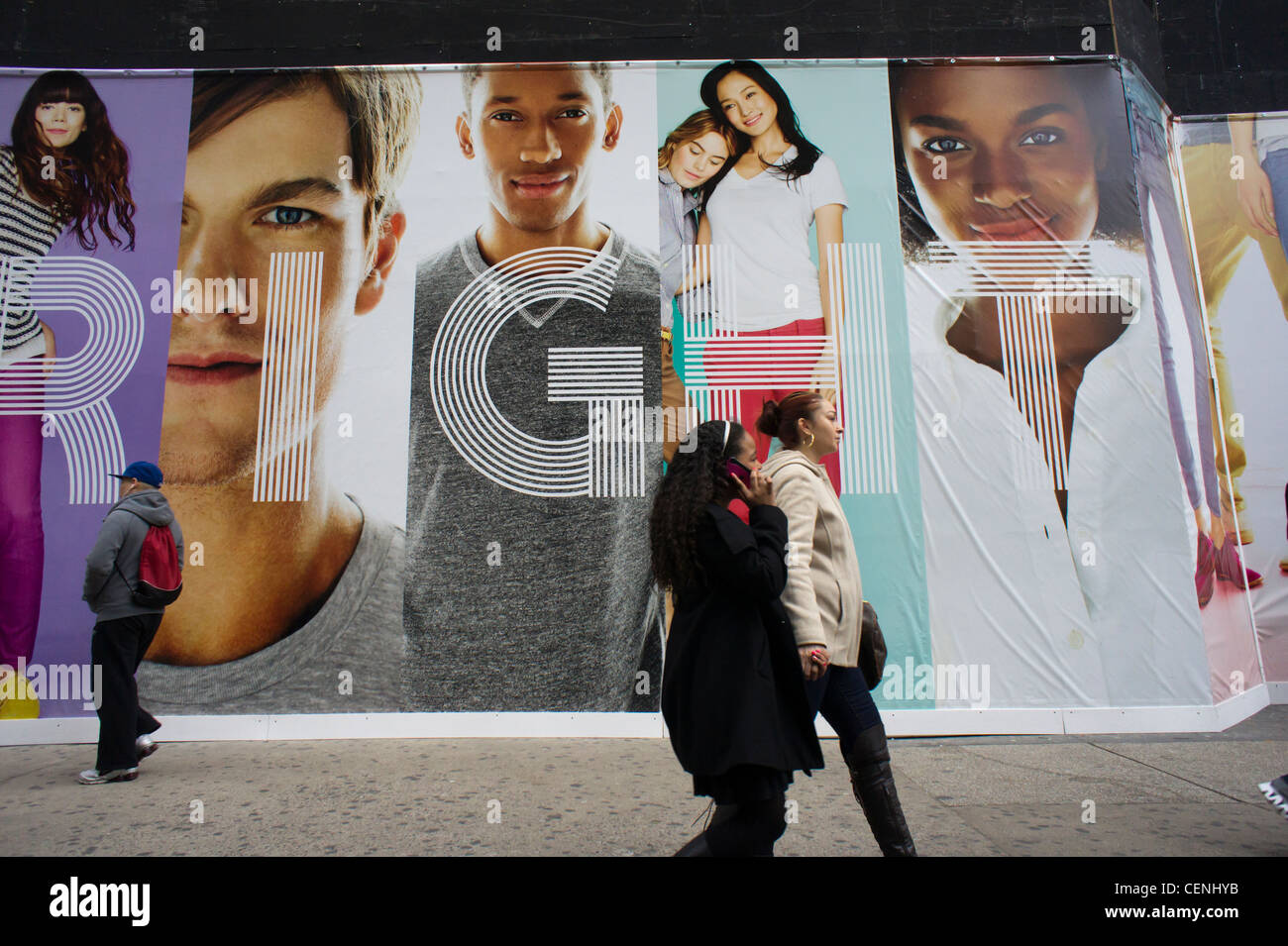 Shoppers pass a promotion for a Gap clothing store, covering its ...