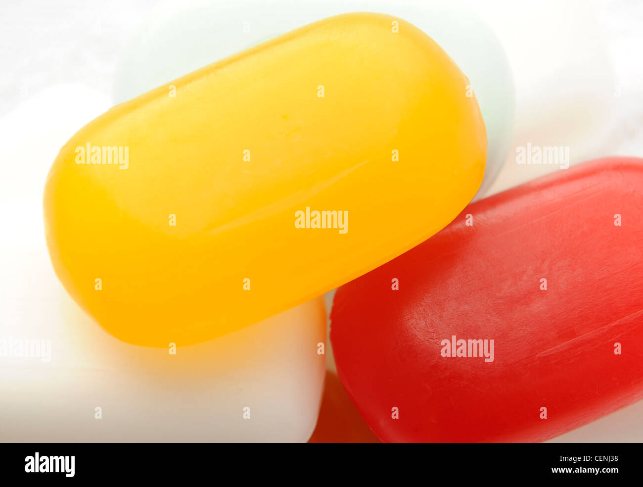 White bars of soap with a red soap bar and yellow bar of soap in the ...