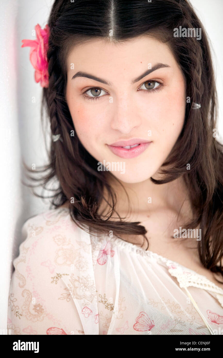Female long brunette hair small plaits on either side and pink flower ...