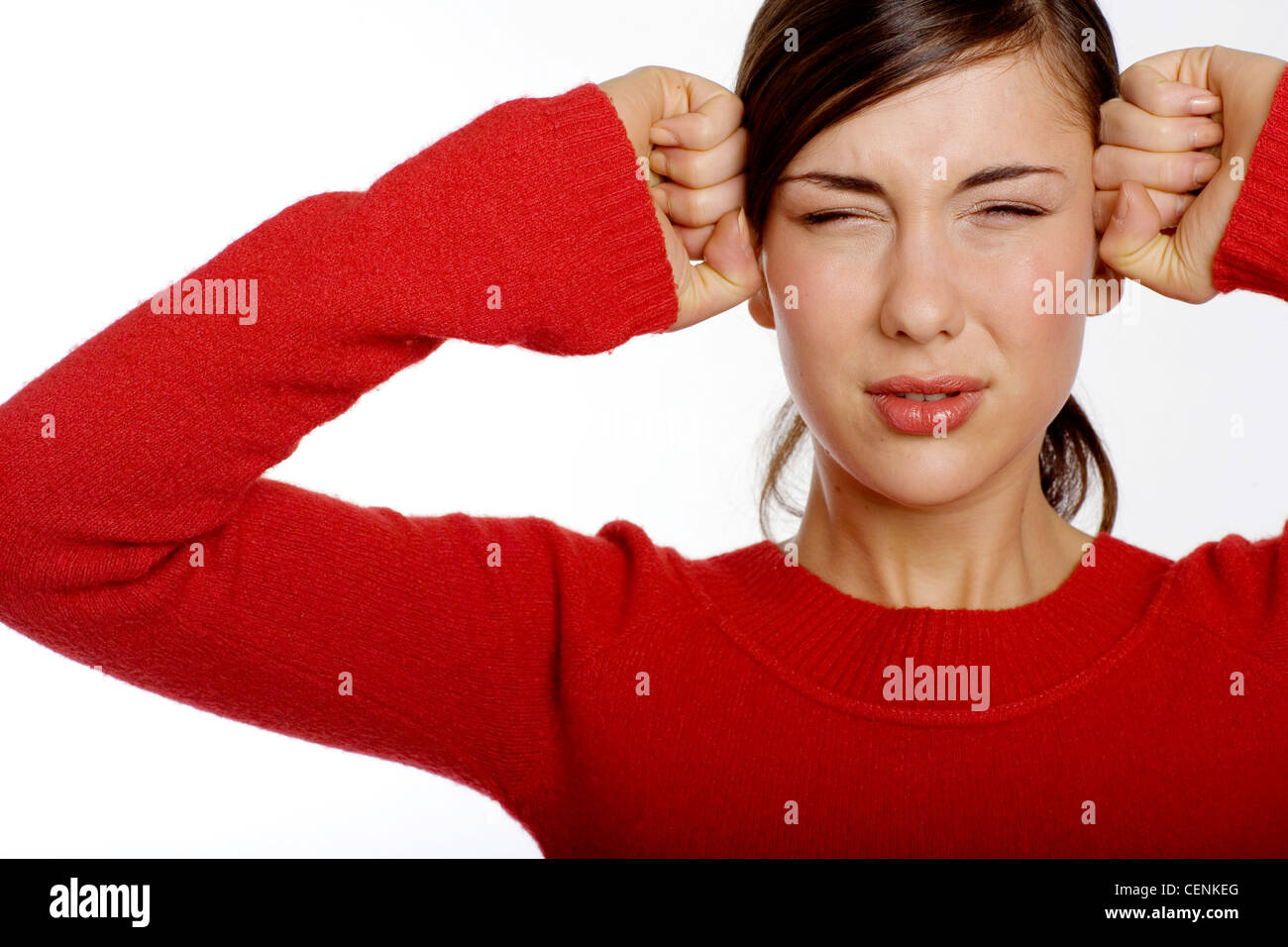 Portrait of a young brunette femalein a red sweater with both hands on ...