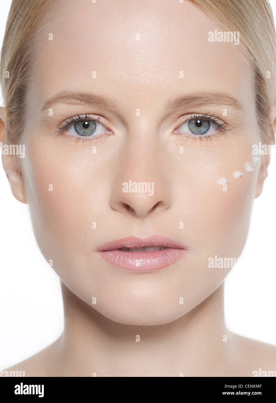 Female blonde hair off her face, wearing subtle make up, applying face ...