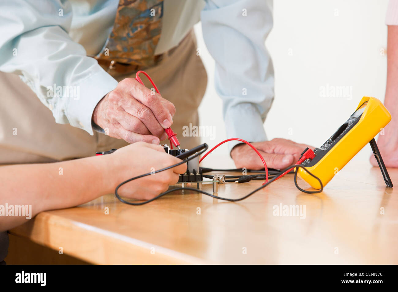 Engineering professor assisting student with multimeter measurement on ...
