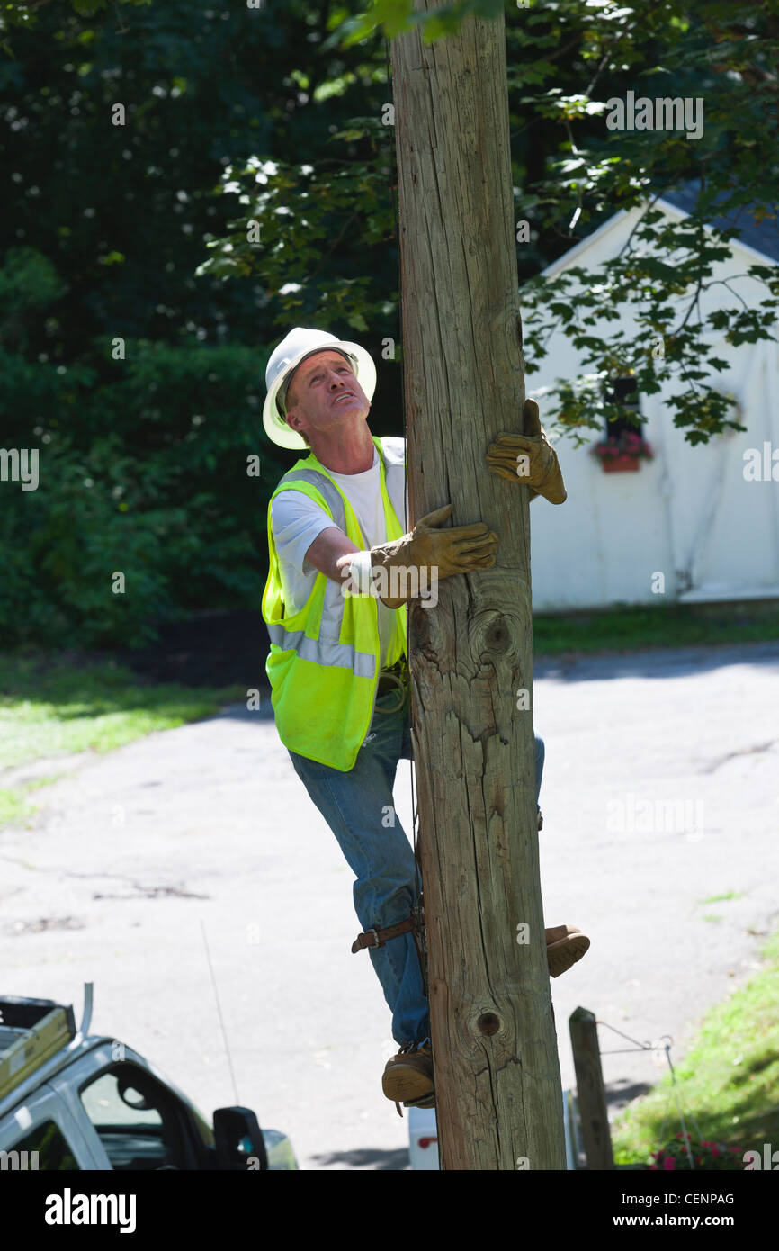 Lineman climbing a pole for installation Stock Photo - Alamy