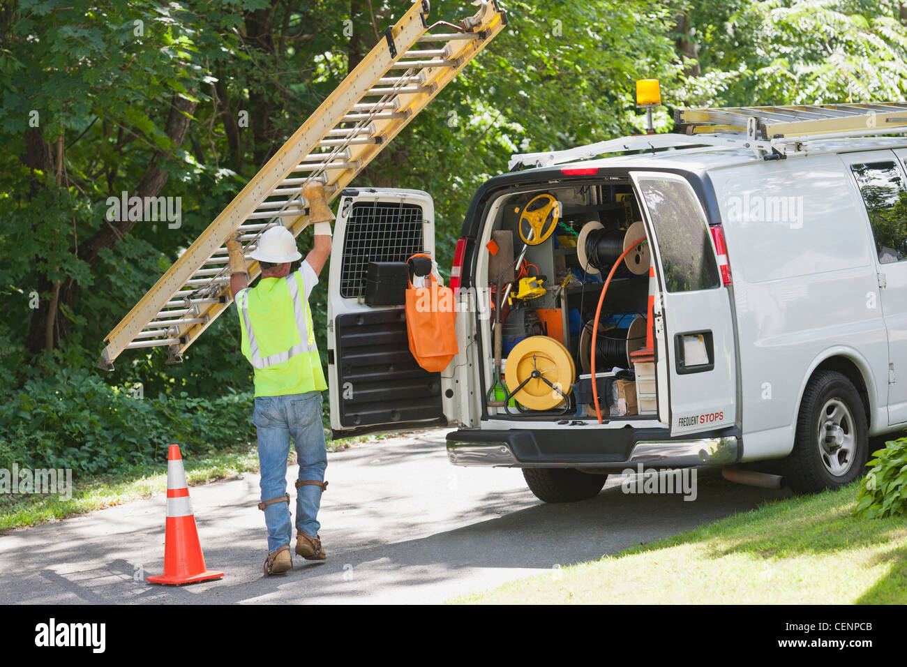 Lineman carrying a ladder back to his truck Stock Photo - Alamy