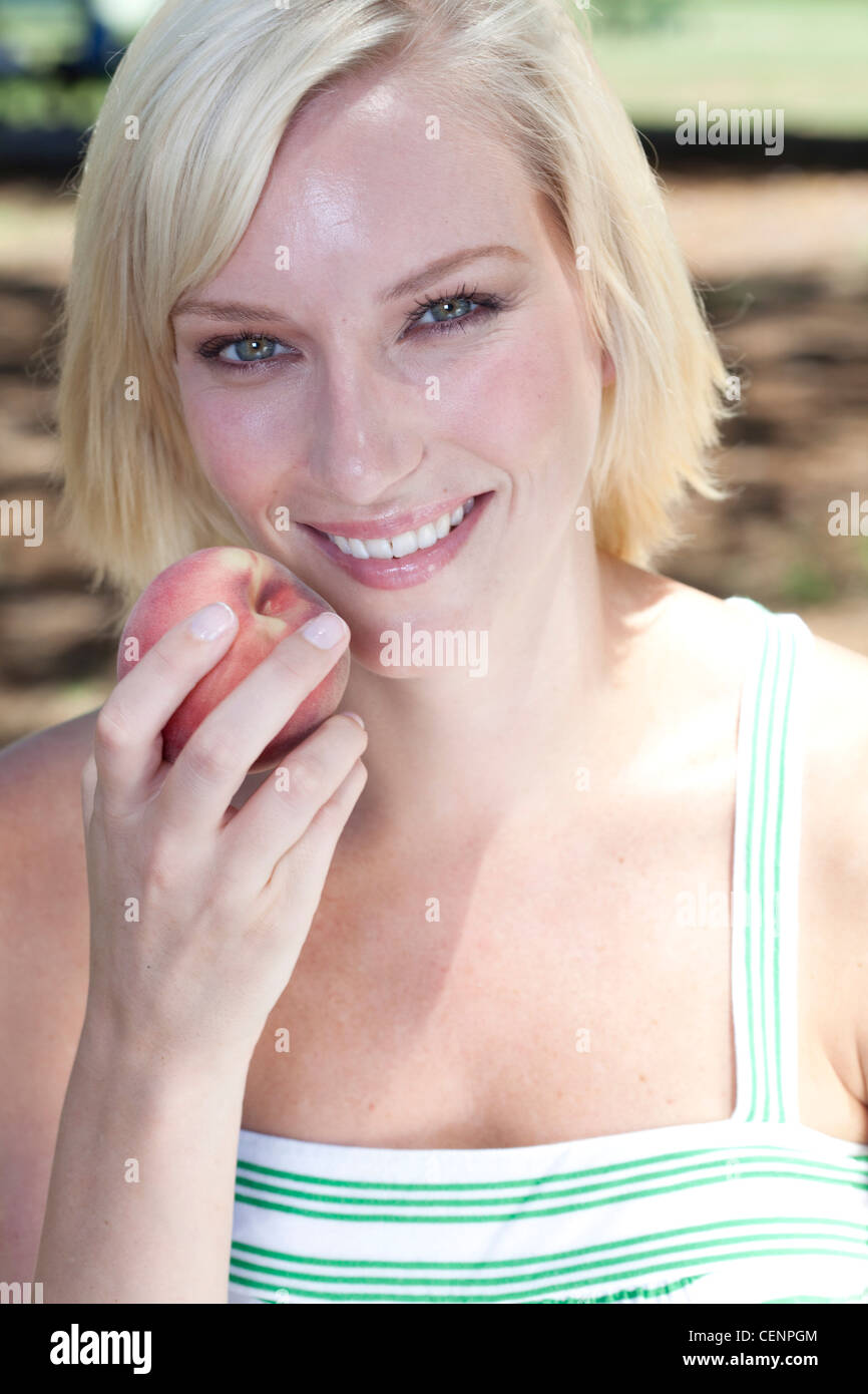 Female eating peach Stock Photo - Alamy