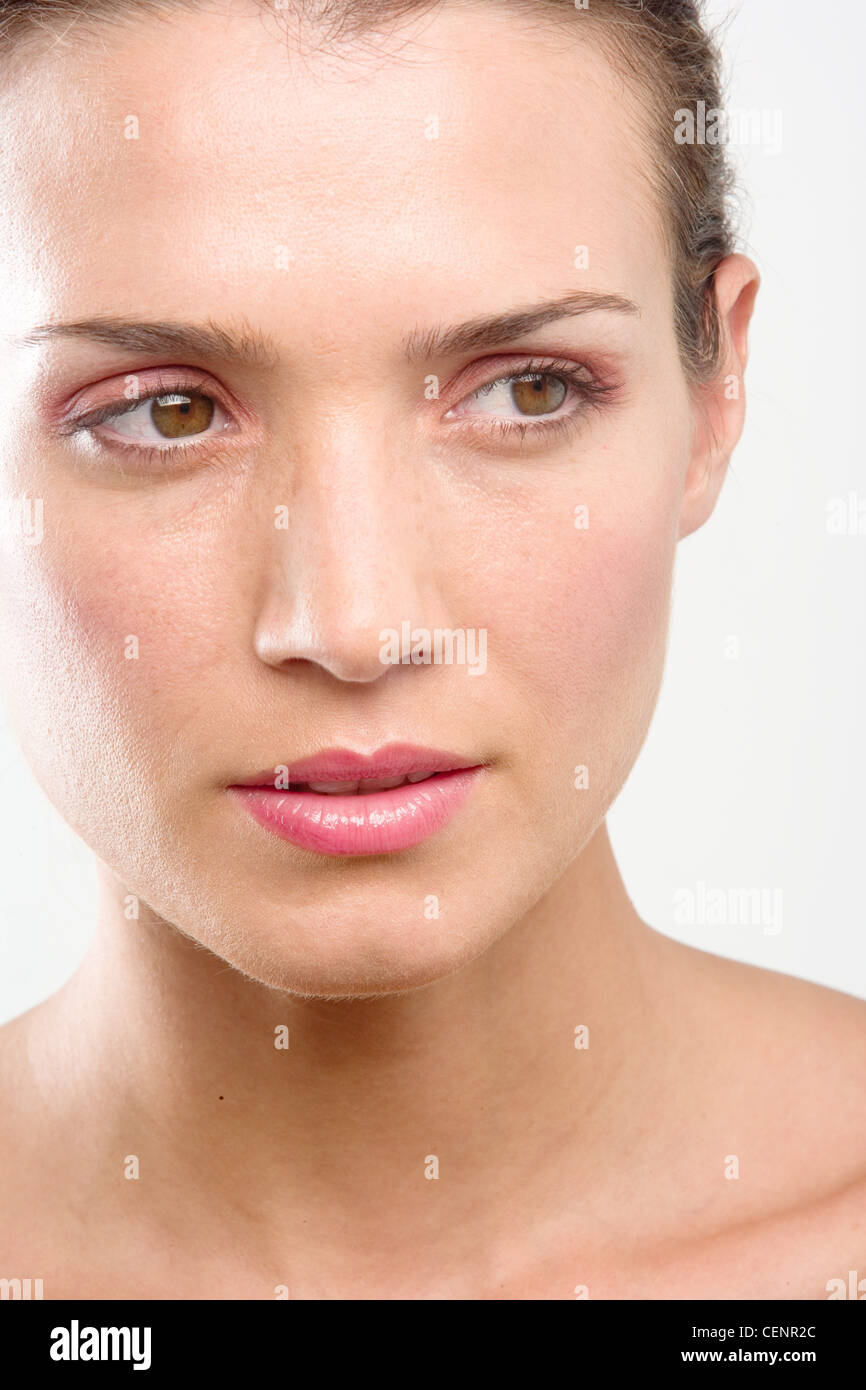Female with brunette hair off face wearing pink eye shadow and lipstick ...