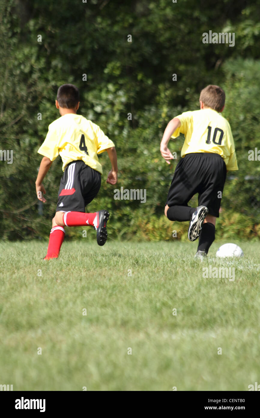 boys Soccer game in sync teammates chasing for ball Stock Photo - Alamy