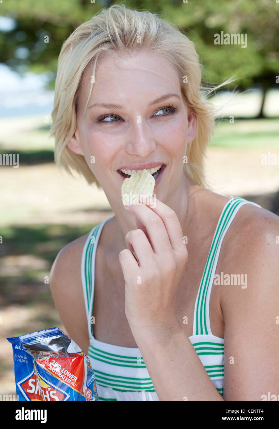Female eating crisps Stock Photo - Alamy
