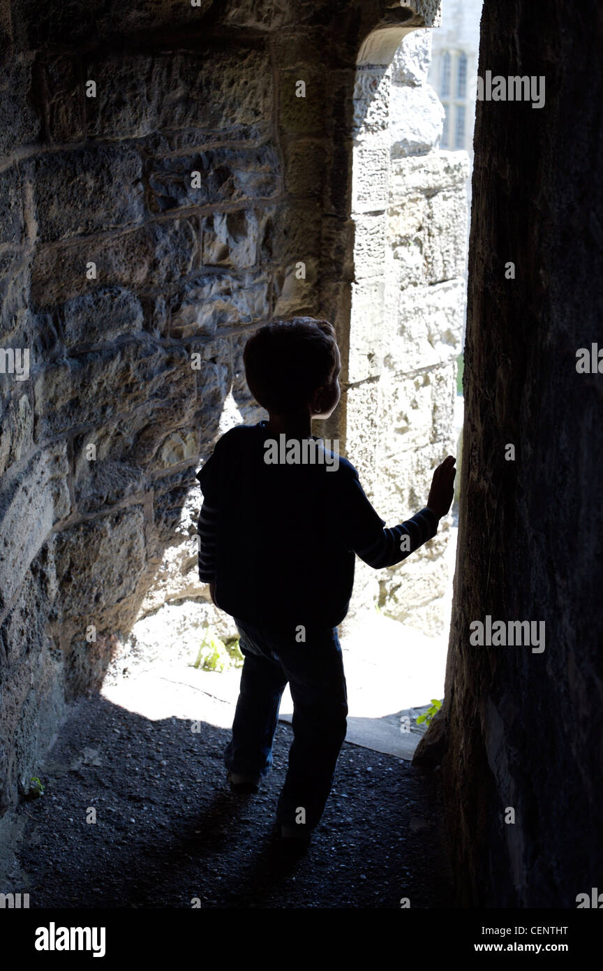 Male child walking under stone passageway Stock Photo - Alamy