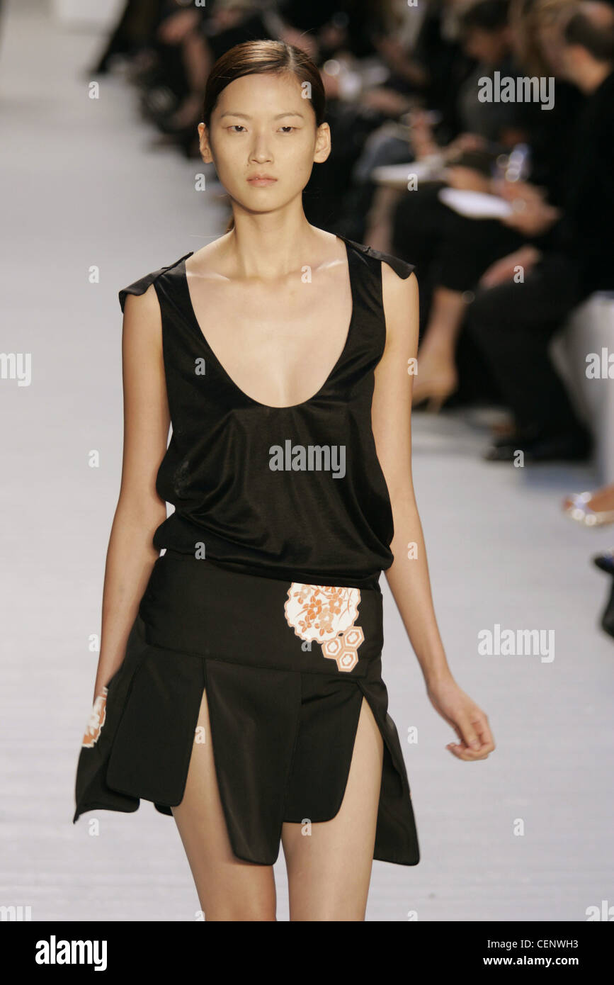 Paco Rabanne Female model black hair pulled back wearing a black scoop ...