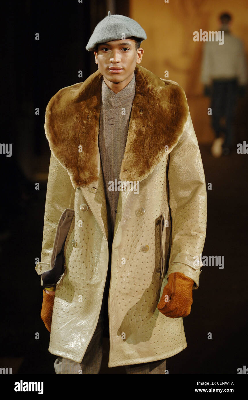 Male model wearing a cream coloured knee length double breasted leather ...