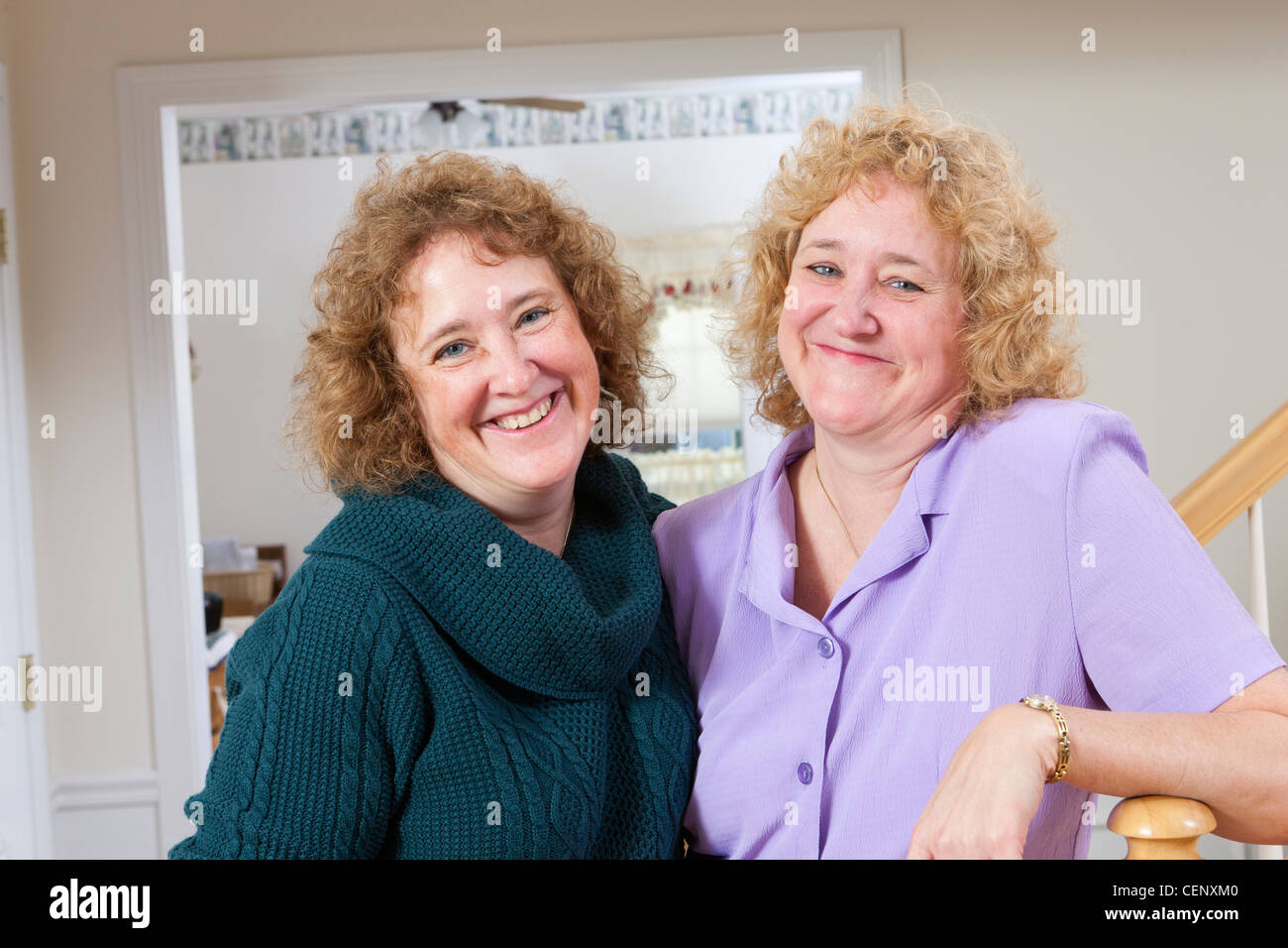 Portrait of twin sisters smiling at home Stock Photo - Alamy