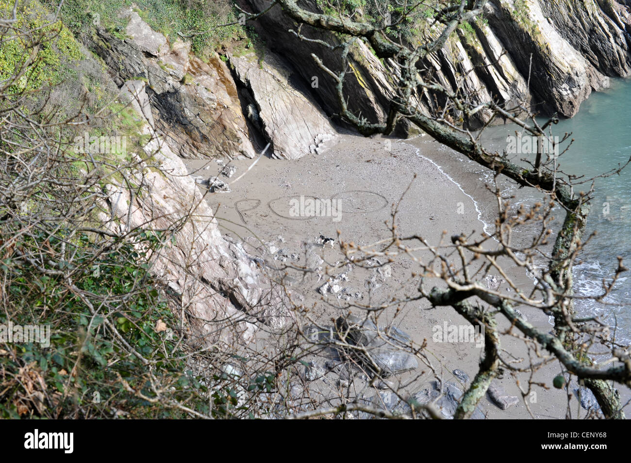 Large letters spelling the word poo written on a sandy beach in protest ...