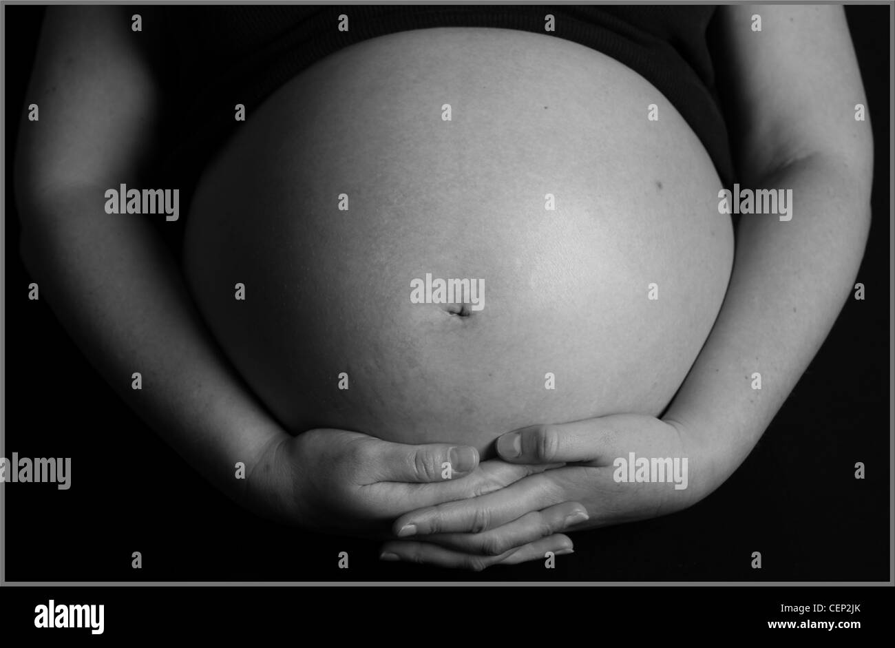 Woman cradling unborn child Stock Photo - Alamy