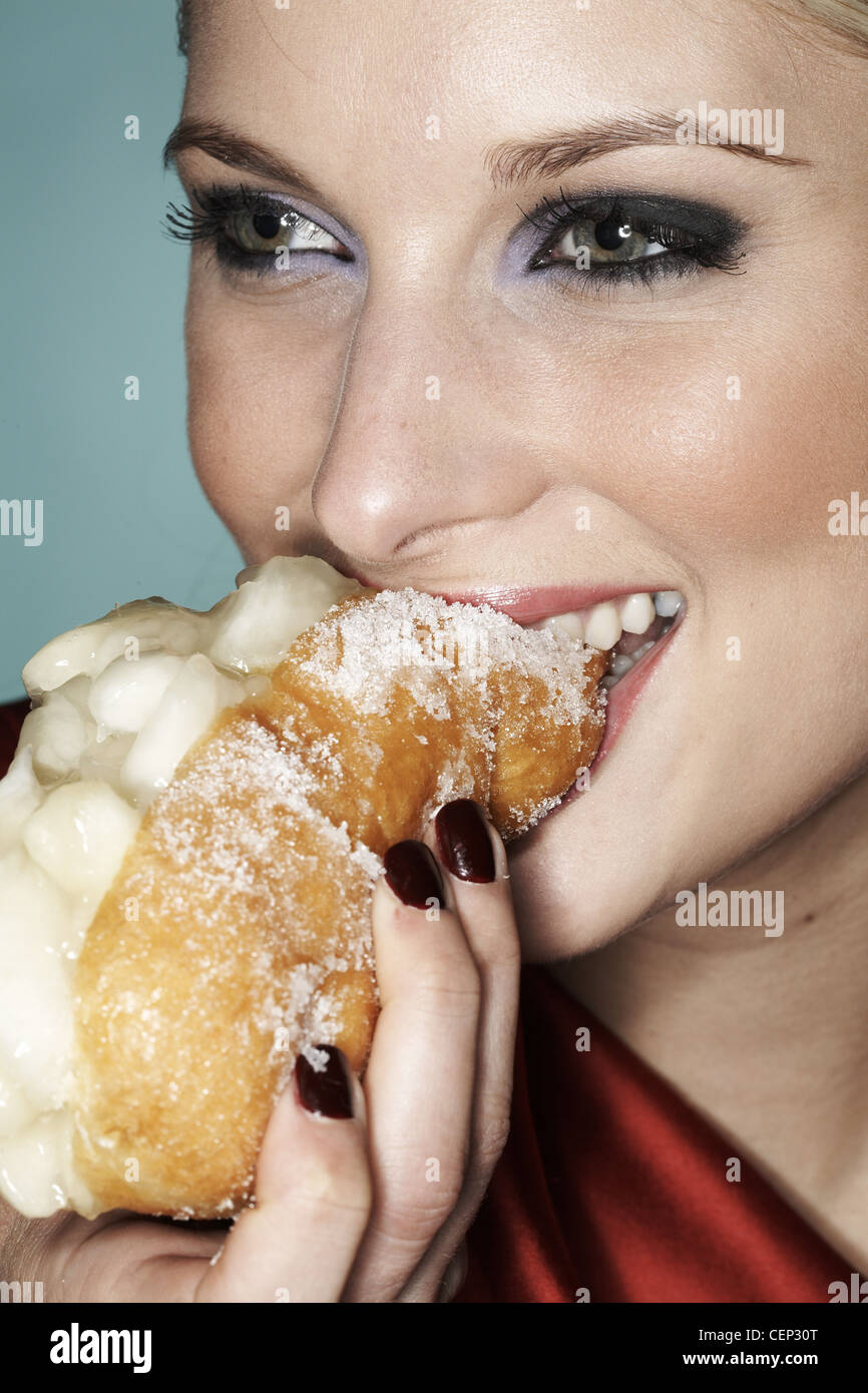 Female biting into a apple filled sugar coated bun Stock Photo - Alamy