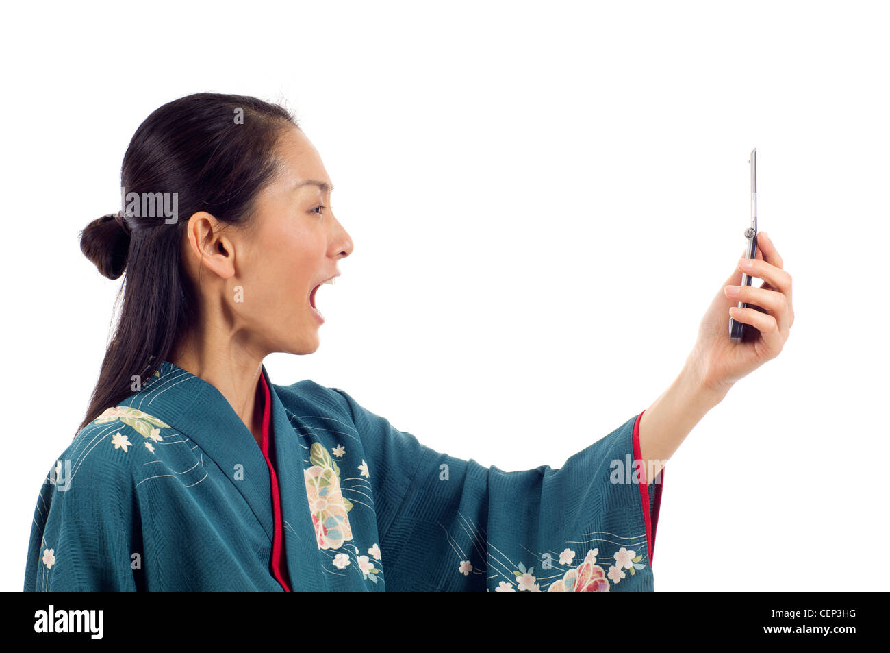 Angry Japanese woman in kimono yelling at her phone isolated over white ...