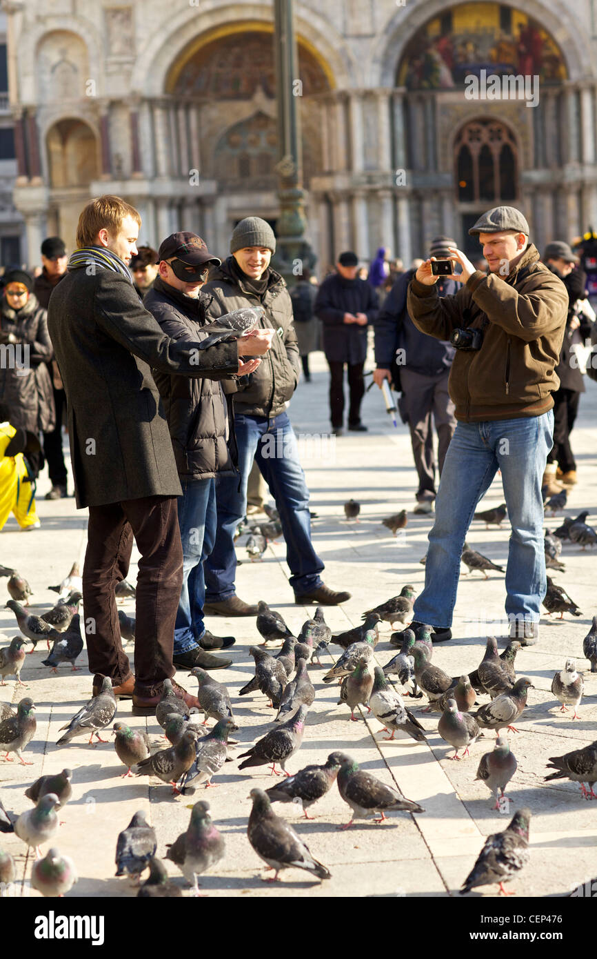Feeding the pigeons in Saint Mark's square in Venice, Italy Stock Photo ...