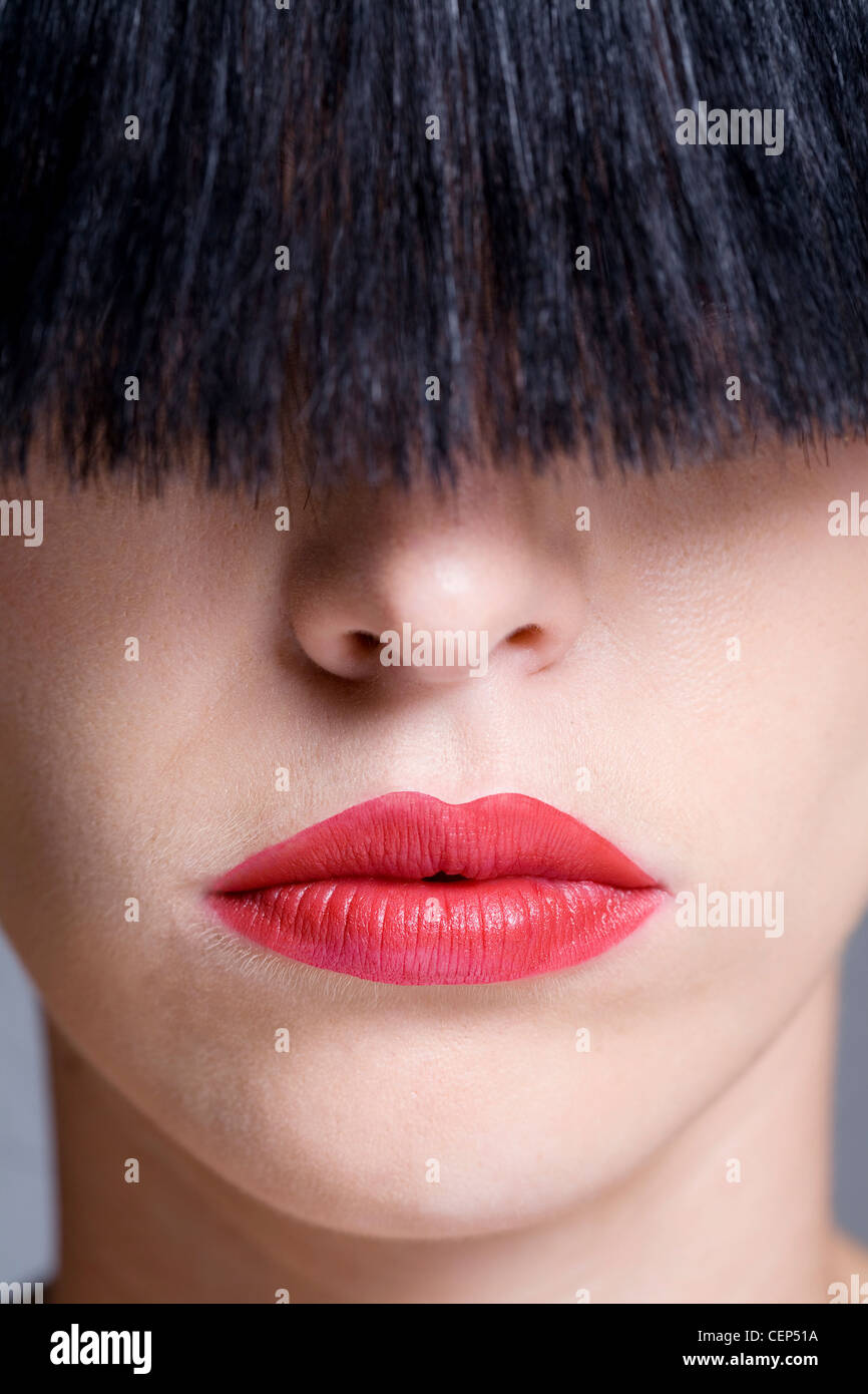 Female a long black fringe covering her eyes with deep pink lipstick ...