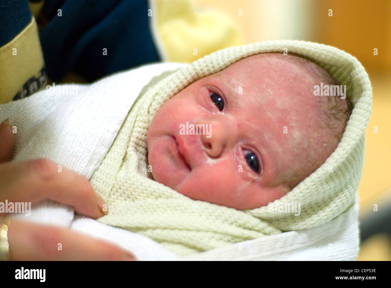 A newborn female baby wrapped in blankets being held by a female ...