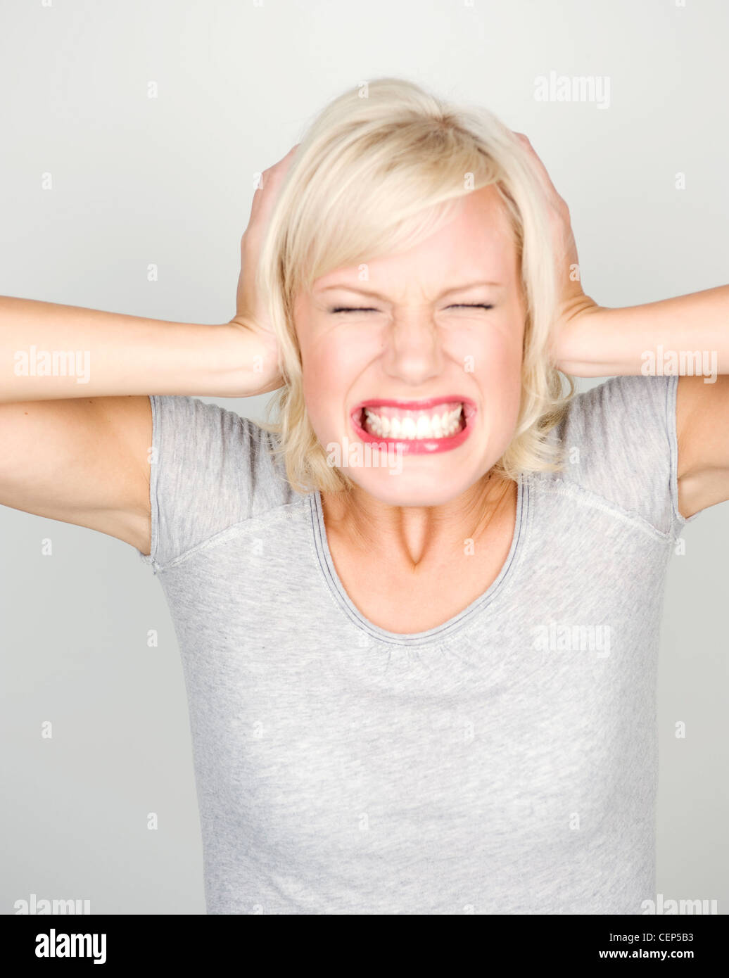 Female with hands over her ears Stock Photo - Alamy