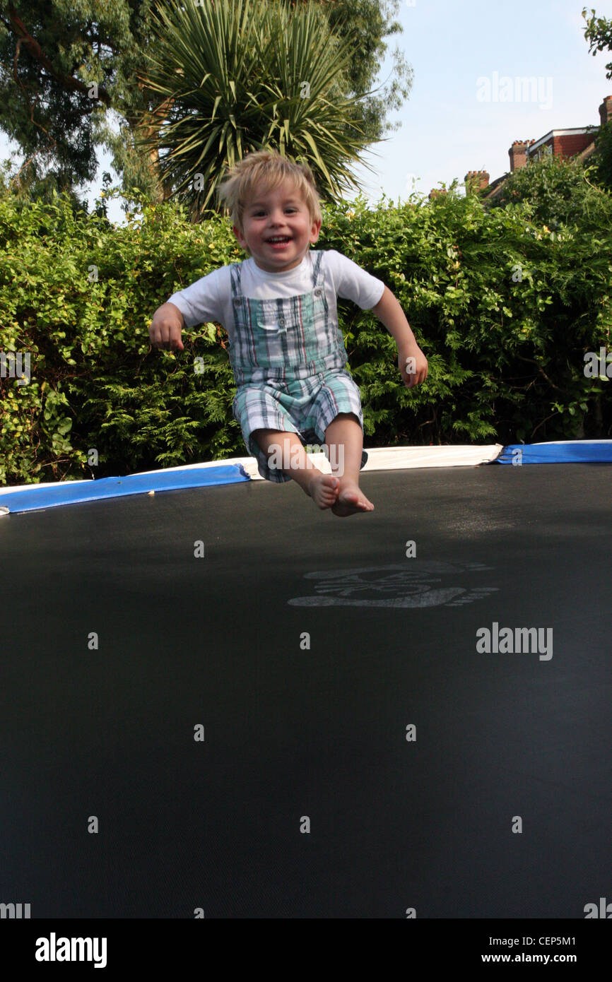 Male child bouncing on a trampoline Stock Photo - Alamy
