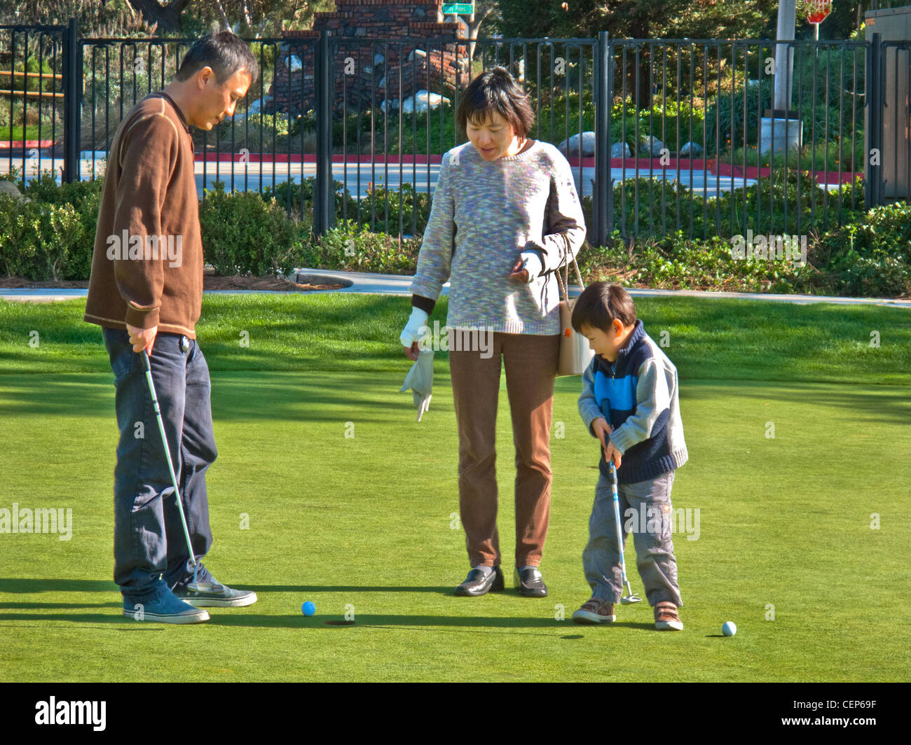 Chinese-American child gets a golf putting lesson in San Diego, CA, as ...