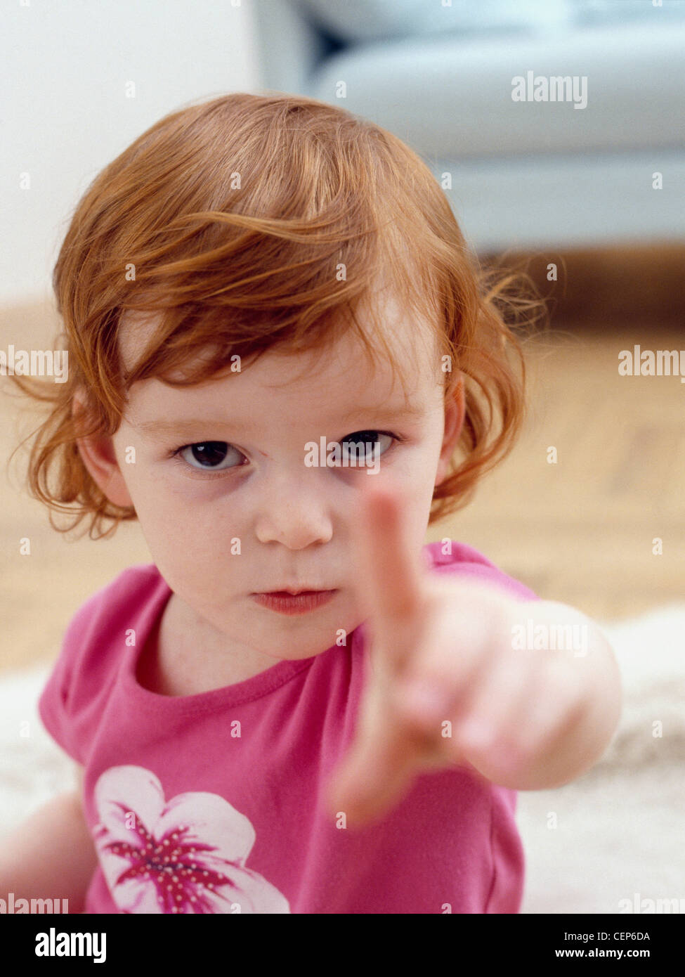 Female toddler ginger hair wearing a short pink dress, sitting on the ...
