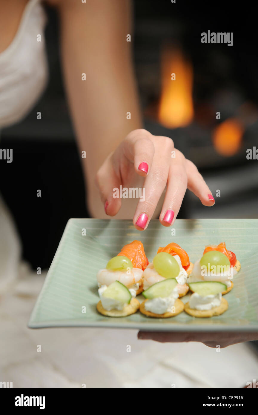 Female hand taking canapes from green plate Stock Photo - Alamy