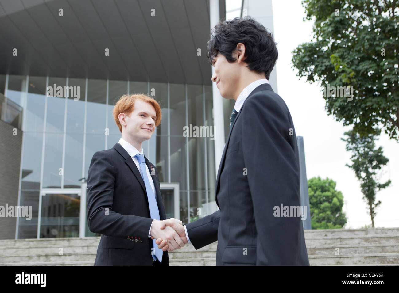 Two businessmen shaking hands Stock Photo - Alamy