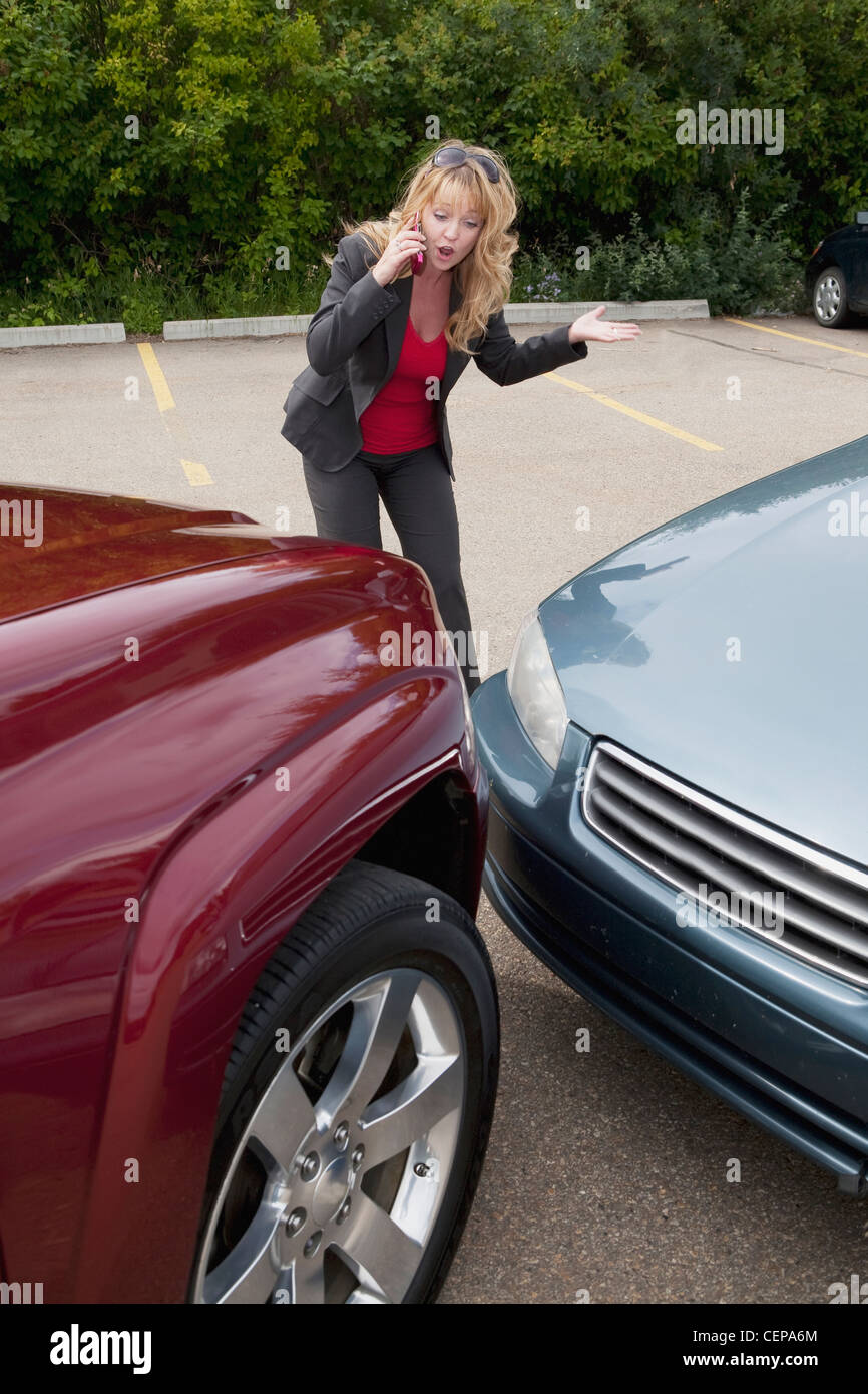 a woman makes a phone call for help after she gets into a car accident ...