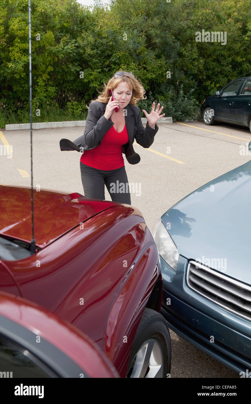 a woman makes a phone call for help after she gets into a car accident ...