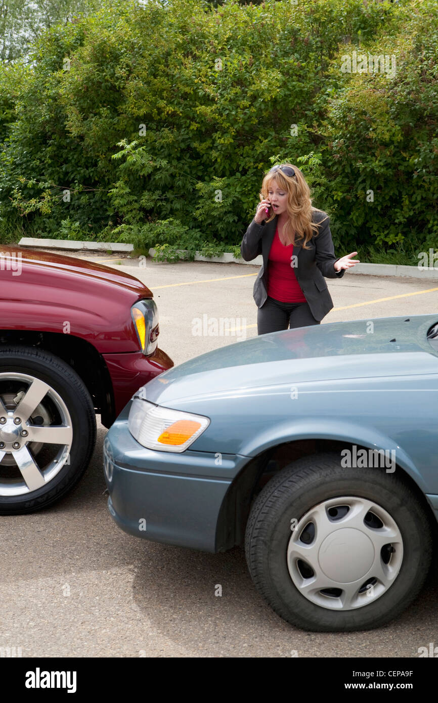 a woman makes a phone call for help after she gets into a car accident ...