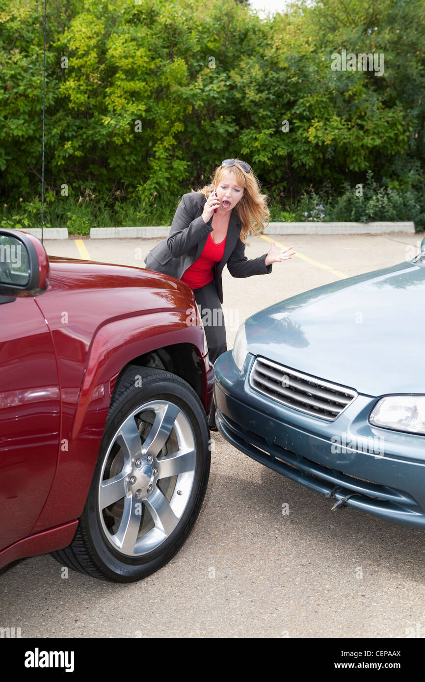 a woman makes a phone call for help after she gets into a car accident ...