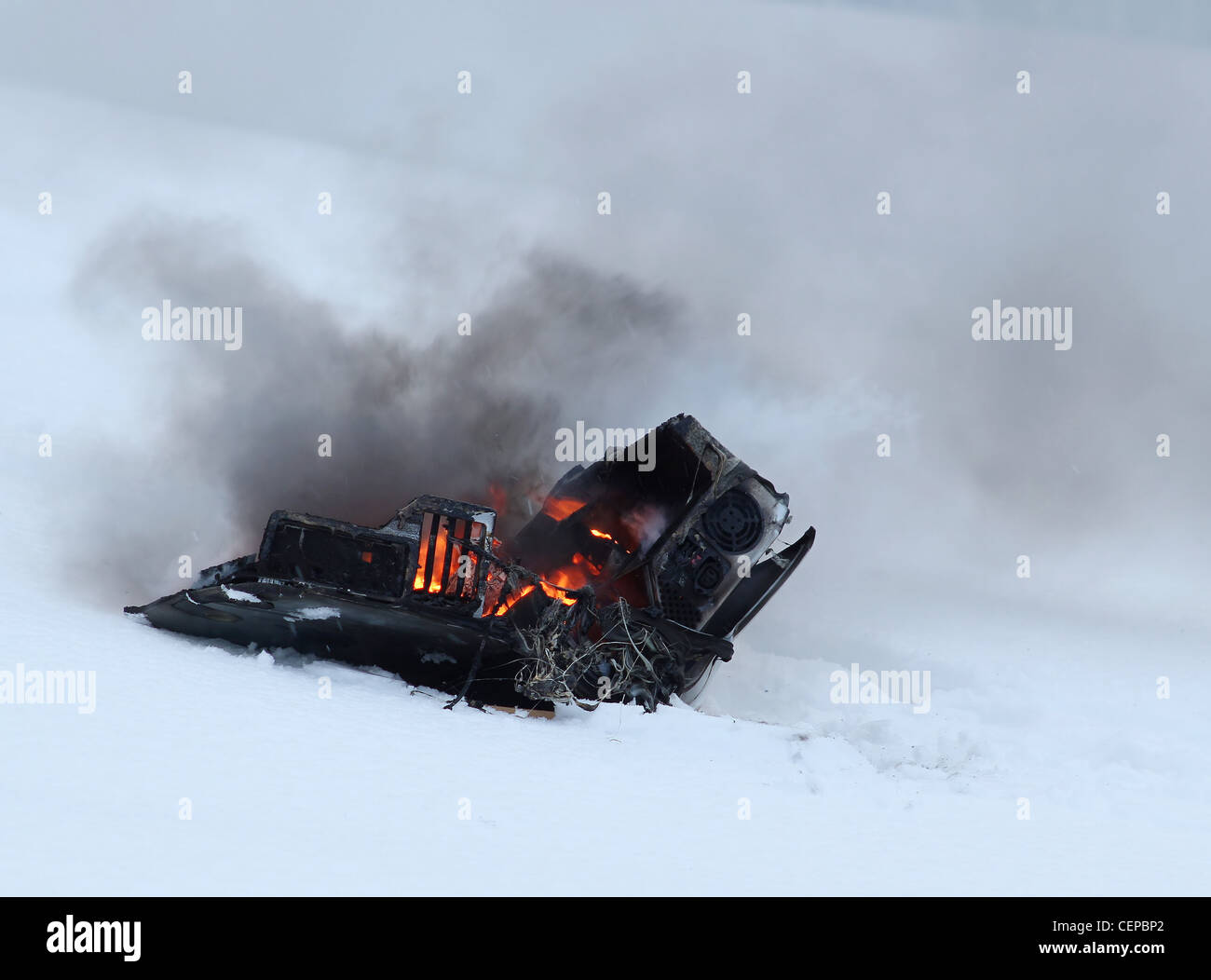 Old computer burning in the snow with flames and smoke Stock Photo - Alamy