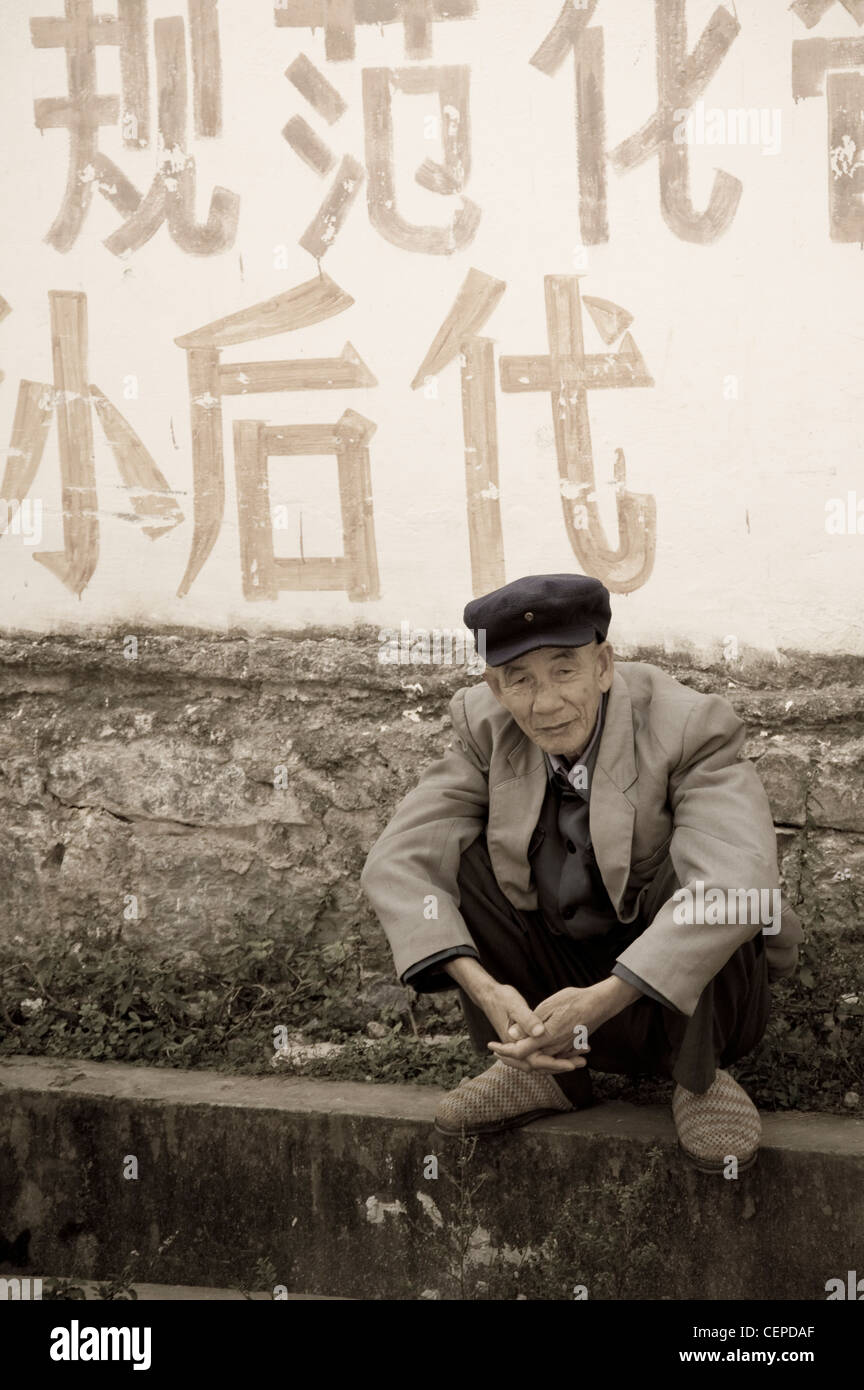 Man Crouched Outdoors In China Stock Photo - Alamy