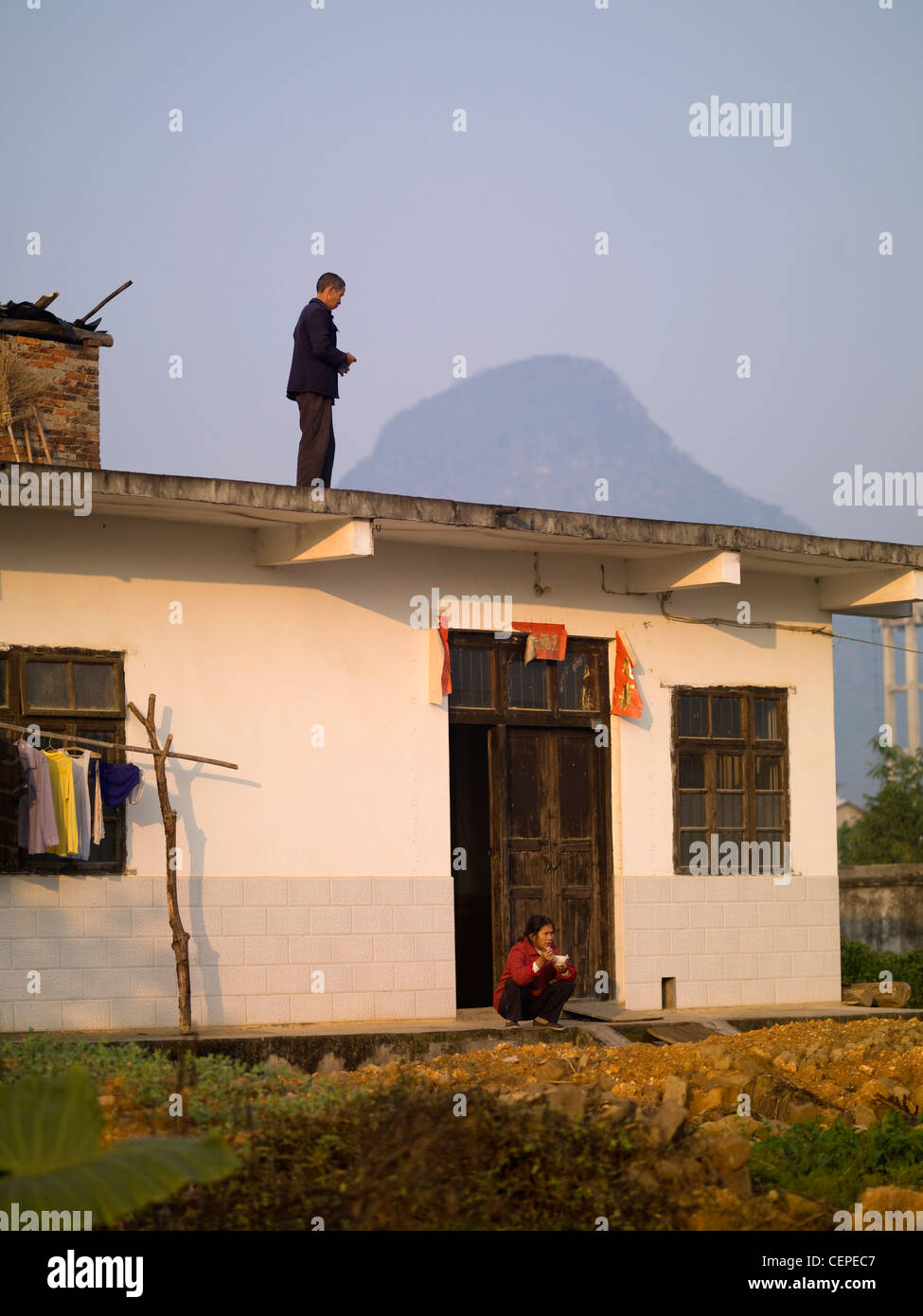 Man On Roof Of House Stock Photo - Alamy