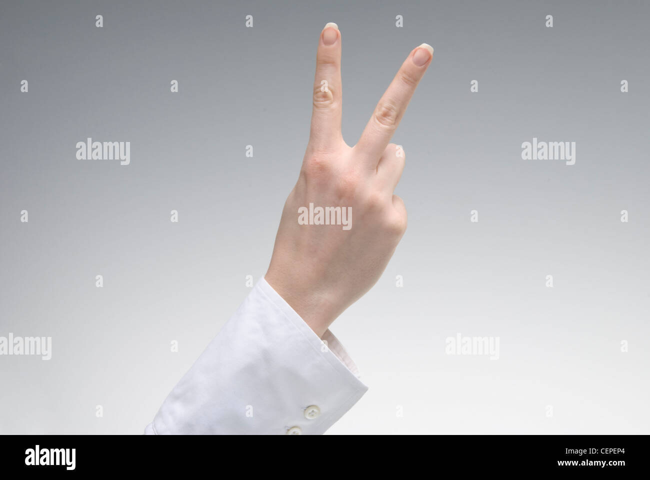 Woman's hand showing Victory symbol over light background Stock Photo ...
