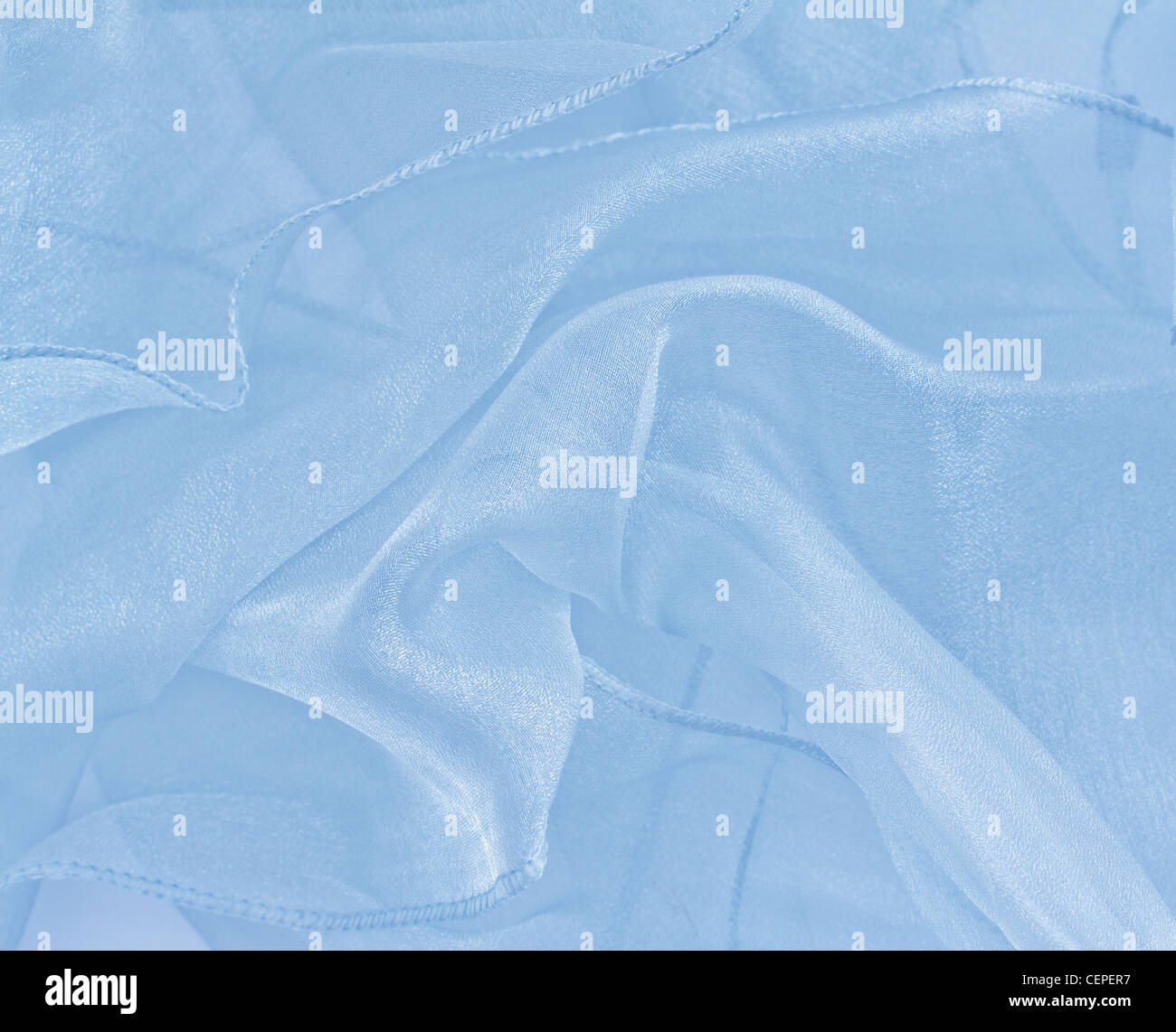 Blue sheer folded fabric background Stock Photo - Alamy
