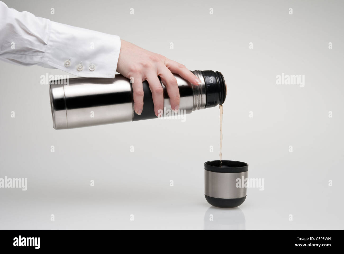 Female hand pouring tea from thermos Stock Photo - Alamy