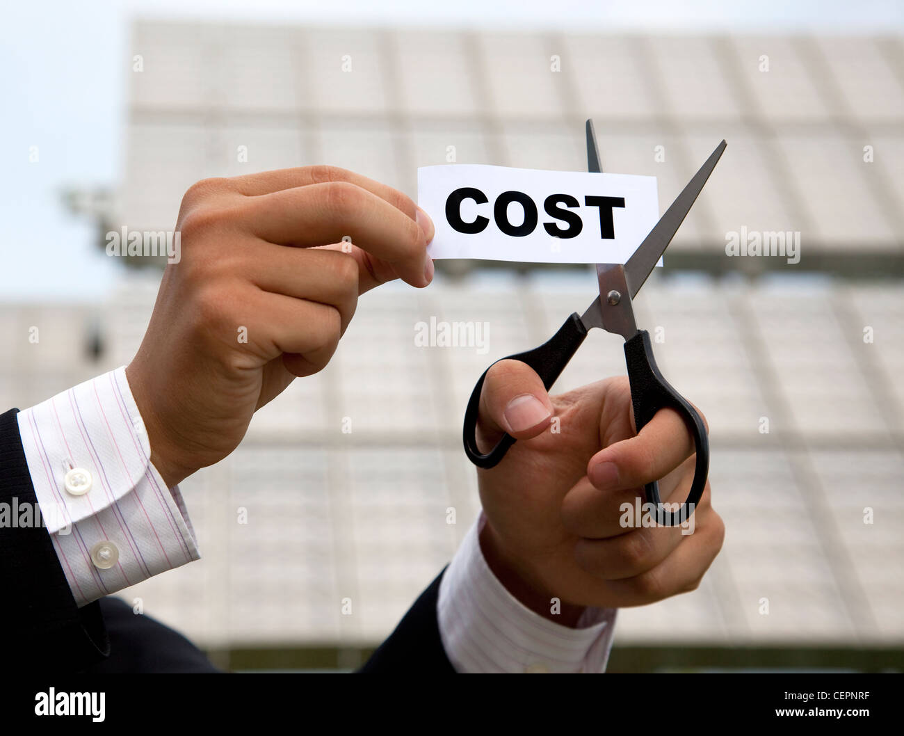 businessman with scissors cutting label cost before solar panel Stock ...