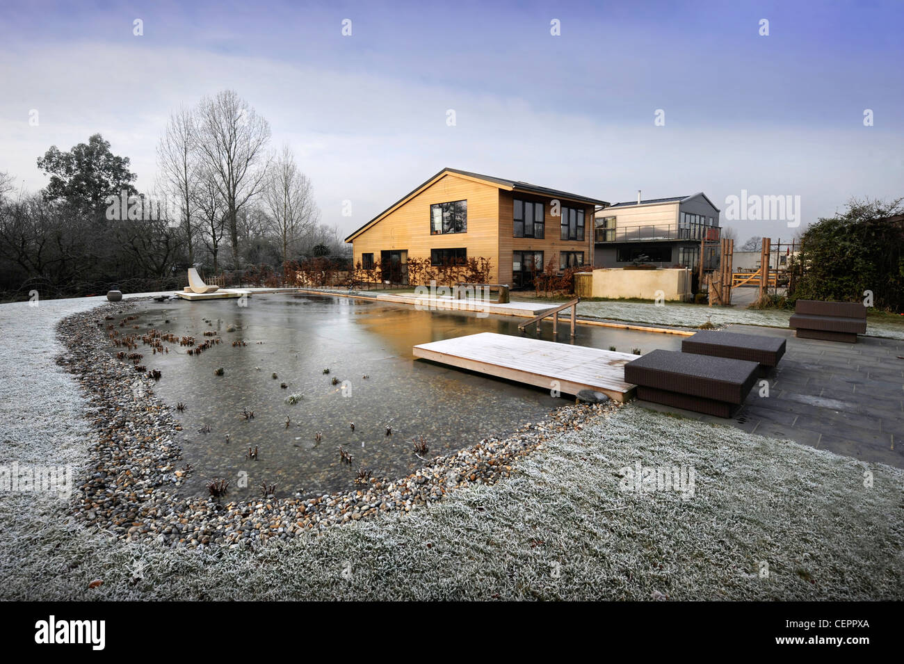 A natural swimming pool which has iced over in winter at a self build ...
