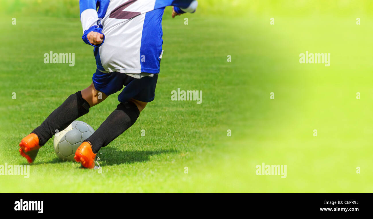 Young school child Soccer player legs dribbling in a match Stock Photo ...