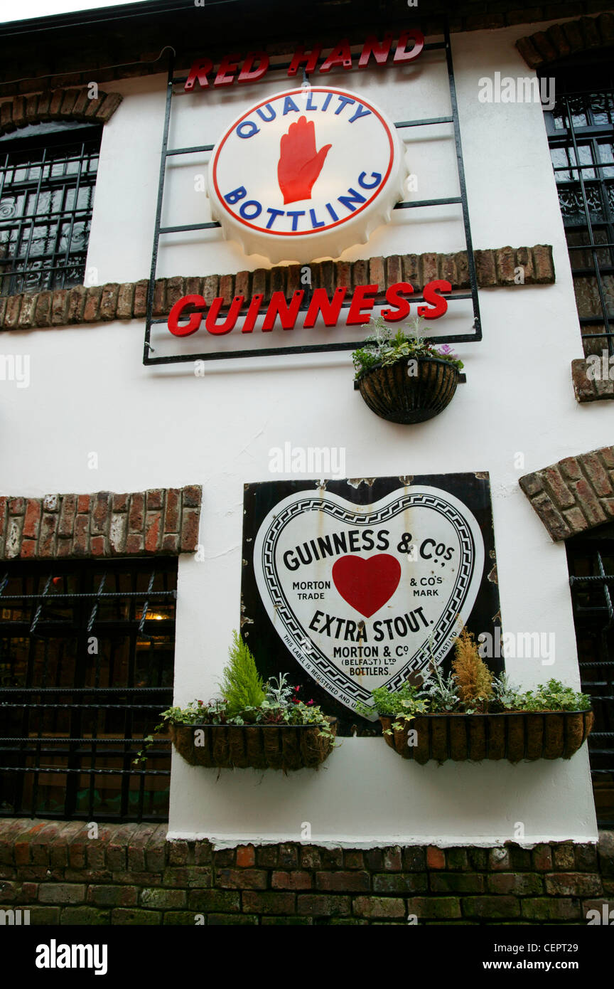 Guinness and quality bottling signs on the side of a pub In Belfast ...