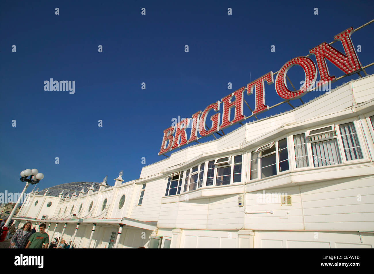 Brighton Pier sign on top of a pier building against a bright blue sky ...