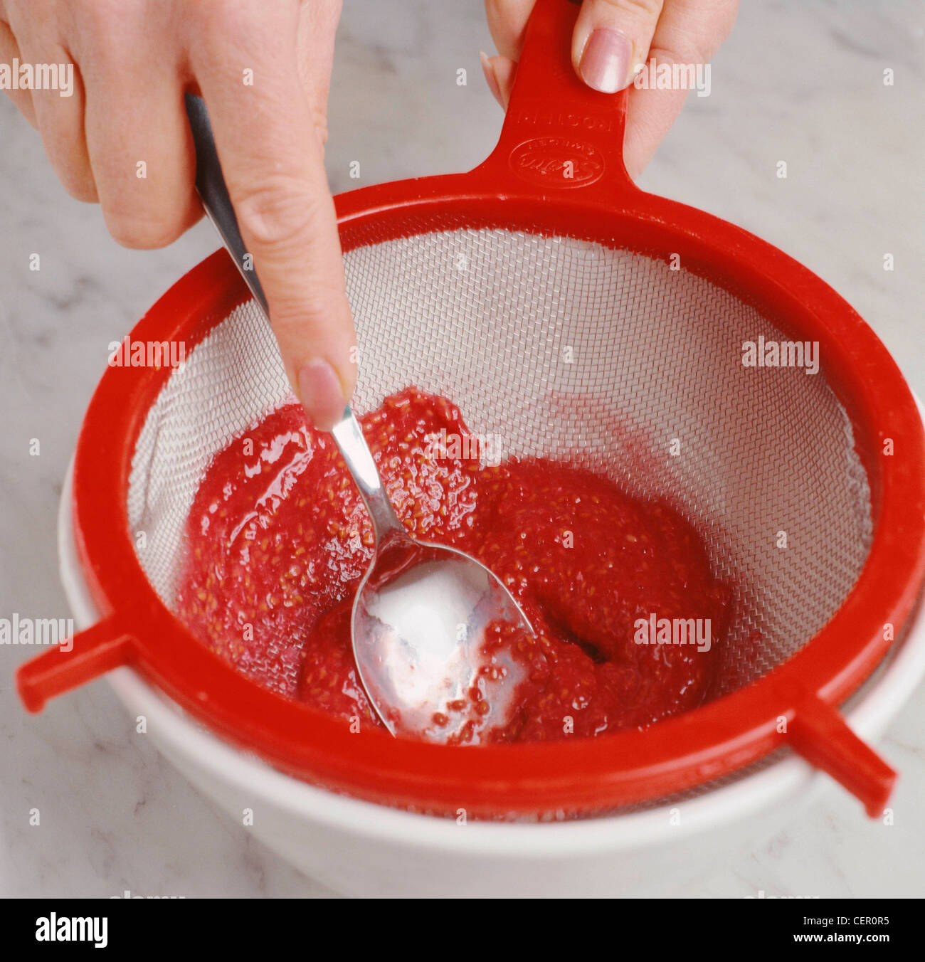 NOMeringue Mountain Metal sieve red plastic handle raspberry puree over ...